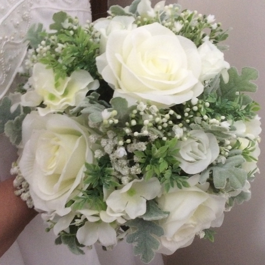 A wedding bouquet collection of artificial roses, hydrangea and gyp ...