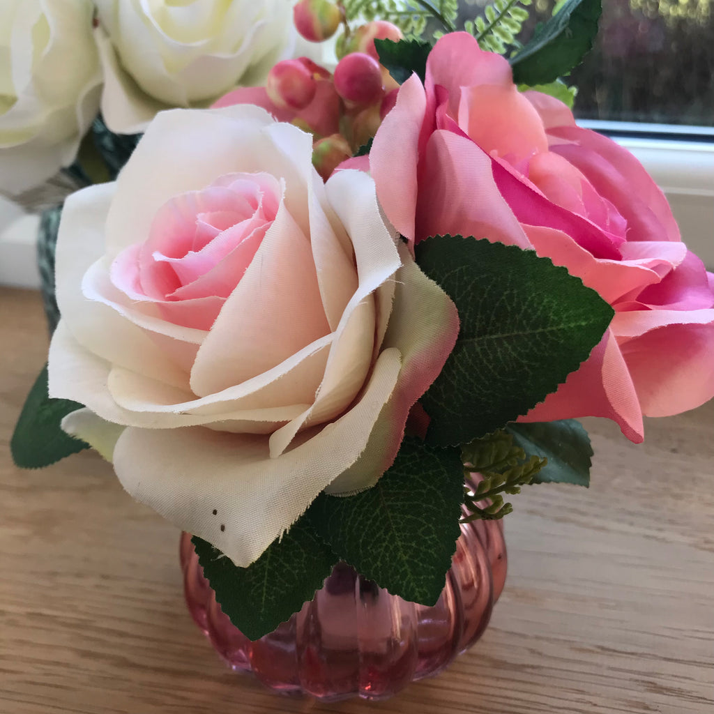 A small posy arrangement of pink silk roses in presention giftbag ...